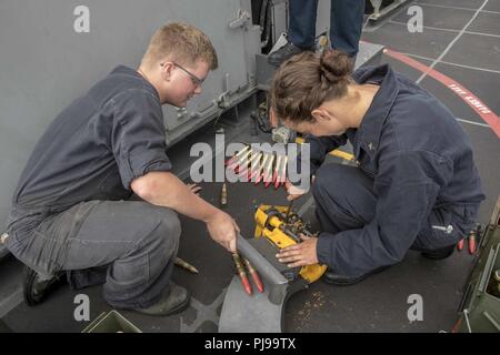 US Navy Fire Controlman perform daily maintenance one of the ship's ...