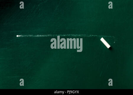 A photo of a line with a piece of chalk on a dark blackboard with copy ...