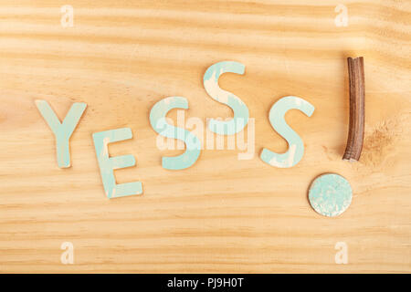 Yes, painted letters forming the word on a wooden background with copy ...