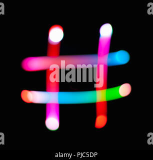 Neon hashtag sign. Light painting yellow hashtag sign against black ...