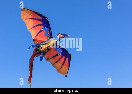 A colourful dragon shaped kite flying against deep blue sky Stock Photo ...