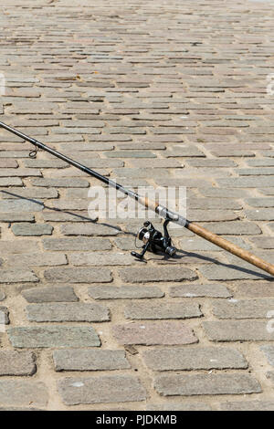 Fishing rod is left on the rock at the Marina Beach Semarang. Indonesia ...