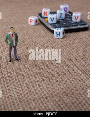 Colorful letter cubes and a calculator beside a figurine Stock Photo ...