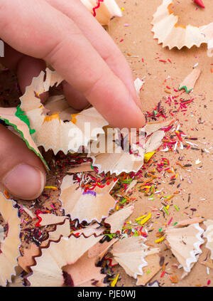 Colorful pencil shavings in hand on a notebook Stock Photo - Alamy