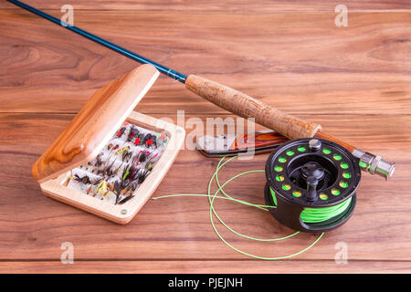 fly fishing rod with a coil and flies lie on old, wooden boards Stock ...