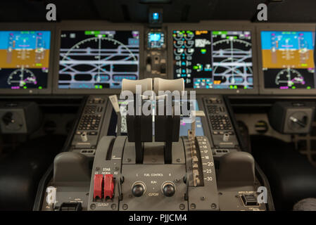 Empty flight deck of a Boeing 787 cockpit with thrust levers in focus ...