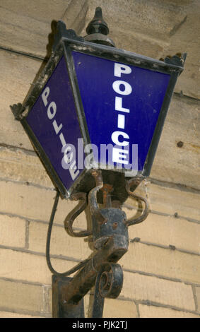 Old fashioned vintage police sign on a globe light hangs on a brick ...