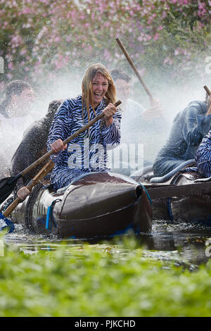 Women rowing a raft in a zebra costume along a river at The Lowland ...