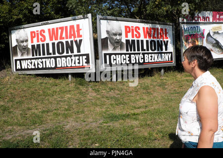 A woman walks past a campaign poster displayed outside the headquarters ...