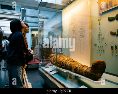 Visitors look at an ancient Egyptian mummy in the British Museum in ...