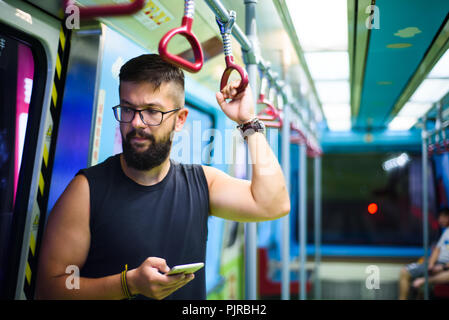 Caucasian man riding subway train Stock Photo - Alamy