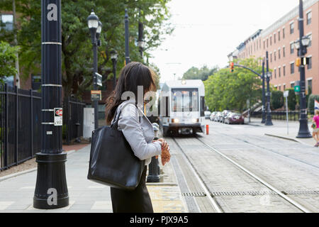 Businesswoman checking time by light rail line Stock Photo - Alamy