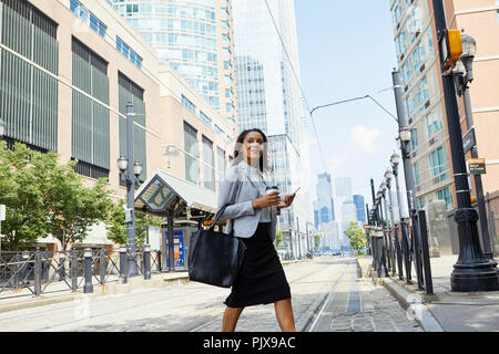 Businesswoman crossing light rail tracks Stock Photo - Alamy