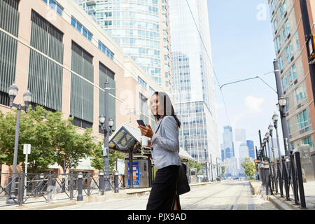 Businesswoman crossing light rail tracks Stock Photo - Alamy