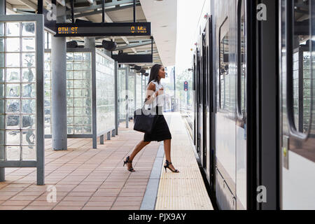 Businesswoman boarding train Stock Photo - Alamy