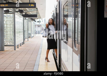 Businesswoman boarding train Stock Photo - Alamy