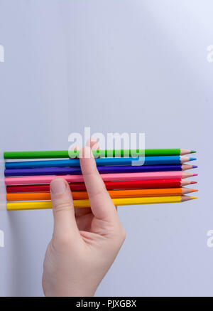 Hand holding color Pencils placed on a white background Stock Photo - Alamy