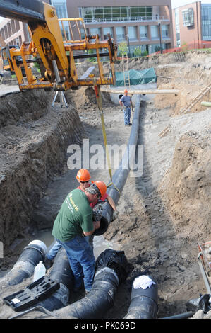 Construction work on pipe laying of pipeline into the trench using a ...