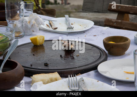 Dining table after dinner. Dirty dishes and leftover food on a table in ...