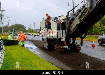 Road works. Asphalt removing machine loading powdered asphalt on the ...