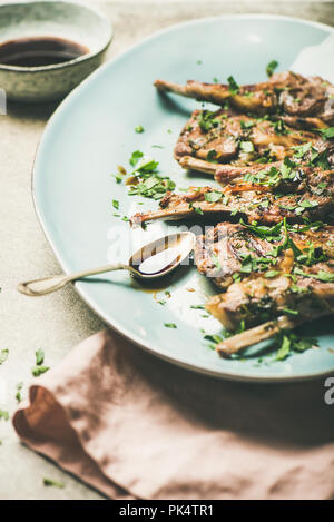 Grilled lamb ribs served over yellow couscous mixed with red peppers ...