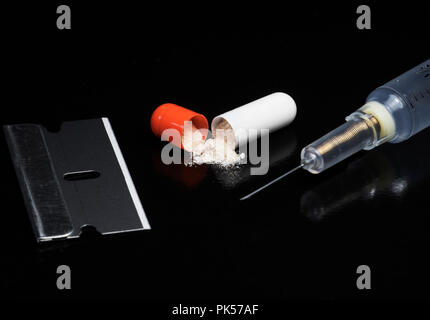 Drug epidemic needles,pills, razor blade on black background. Isolated ...