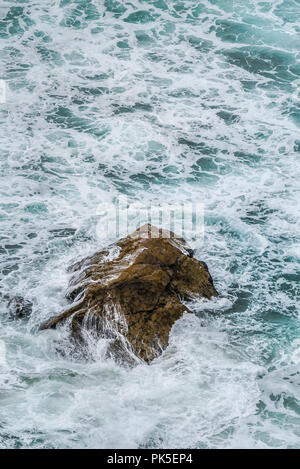 Choppy sea swirling around a rock Stock Photo - Alamy
