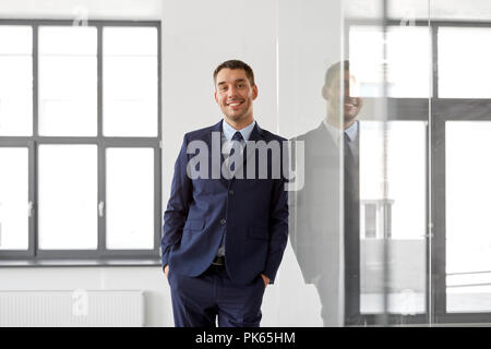 smiling businessman at office glass wall Stock Photo - Alamy