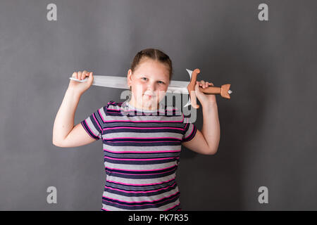 A strong, stout school-age girl with a sword in her arms Stock Photo ...