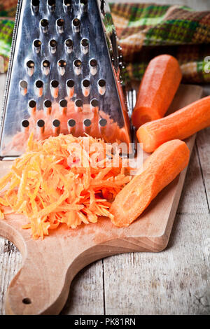 metal grater and fresh carrots closeup on cutting board Stock Photo - Alamy