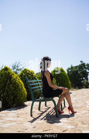 Young Woman sat on Bench Reading Stock Photo - Alamy