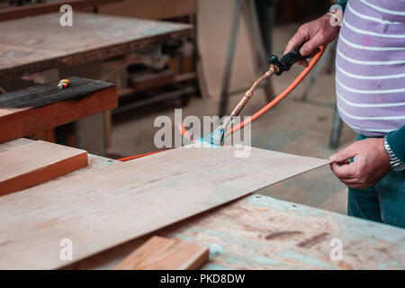 Burning wood planks in carpentry joint in Italy. Detail of gas burner ...