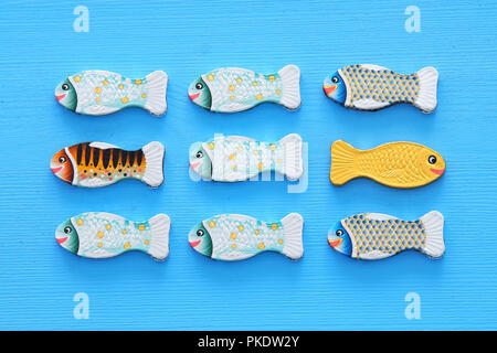 one fish swimming the opposite way the rest of the school is toned with ...