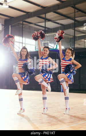 Beautiful young cheerleader on color background Stock Photo - Alamy