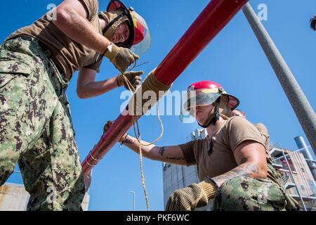 Damage Controlman 2nd Class Shane Rutherford practices using a portable ...