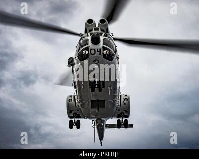 A SA-330 Puma helicopter flies over the fantail of the Australian ...