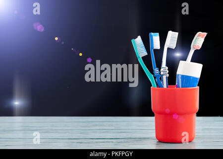 Toothbrushes and toothpaste in a red container on a background of ...