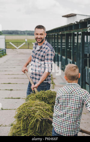 Father, son and together in ranch for farming with livestock ...