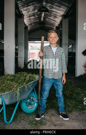 Male farmer with pitchfork standing in cowshed Stock Photo - Alamy