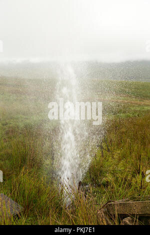 Water spurting out of an old victorian water pipe on moorland in ...