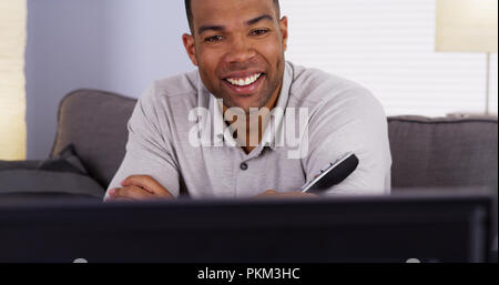 African man flipping through channels on TV Stock Photo - Alamy