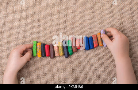 Toddlers hand putting crayons in line on canvas Stock Photo - Alamy