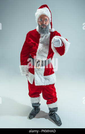 Portrait of bearded santa claus pointing with finger isolated on red ...