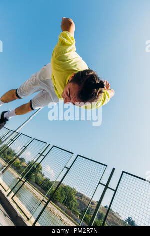 Sportsman jumping over obstacles while exercising parkour tricks Stock ...