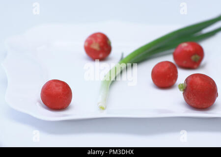 radish and green onion on light background Stock Photo - Alamy