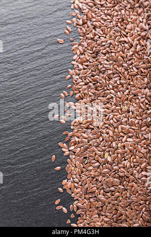 Flax seeds are scattered on a black slate background Stock Photo - Alamy