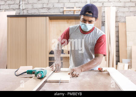worker at carpenter workspace cutting the wood board using saw t Stock ...