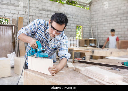 worker at carpenter workspace cutting the surface of furniture u Stock ...