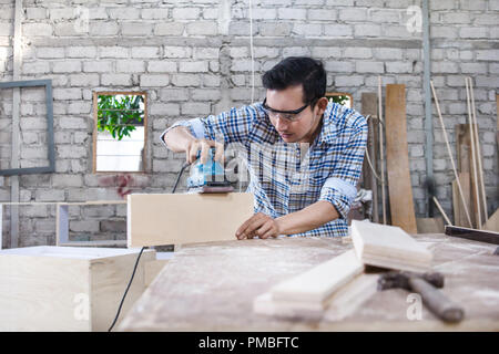 worker at carpenter workspace cutting the wood board using saw t Stock ...
