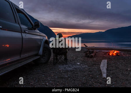 A man sits near a bonfire on a cold and rainy day in Srinagar, Indian ...